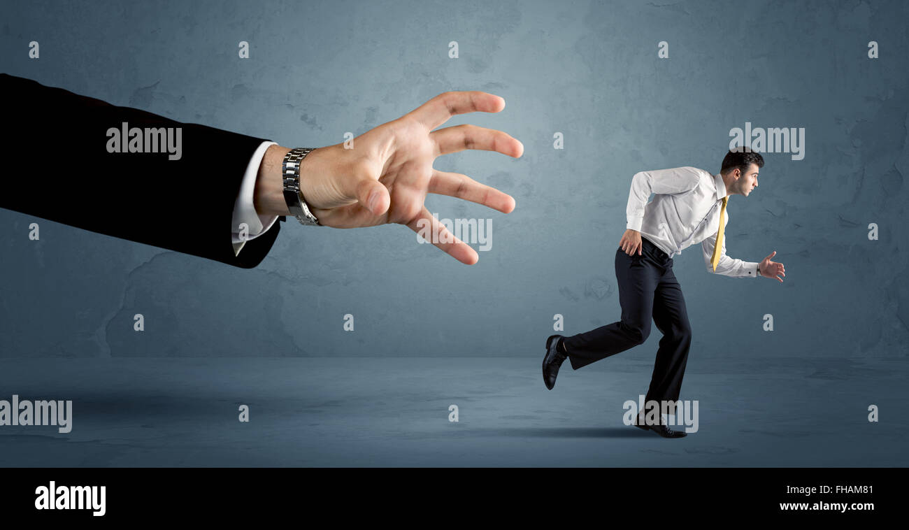 Business man running away from a huge hand concept Stock Photo - Alamy