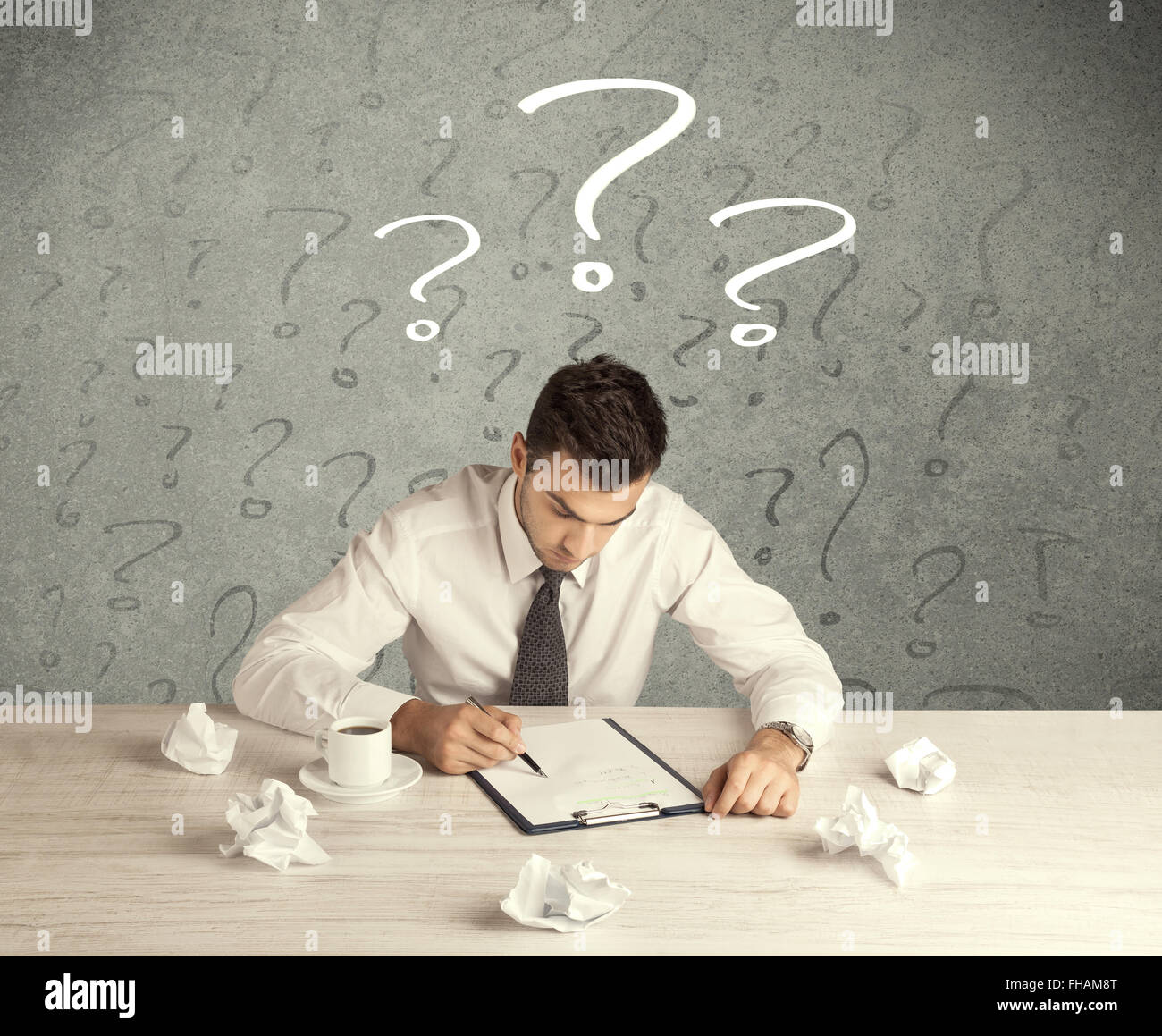 Businessman at desk with question mark Stock Photo - Alamy