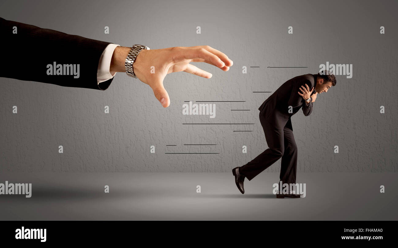 Businessman running away from a huge hand Stock Photo - Alamy