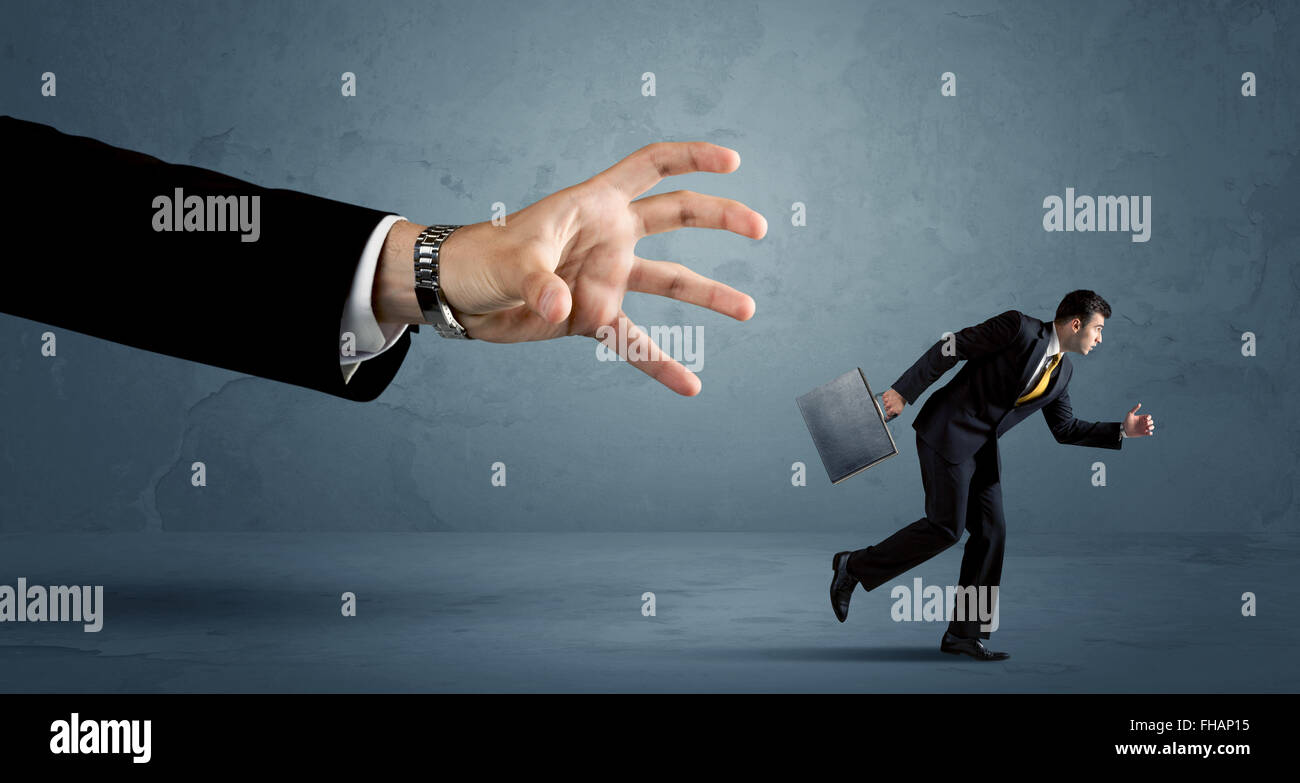 Business man running away from a huge hand concept Stock Photo - Alamy