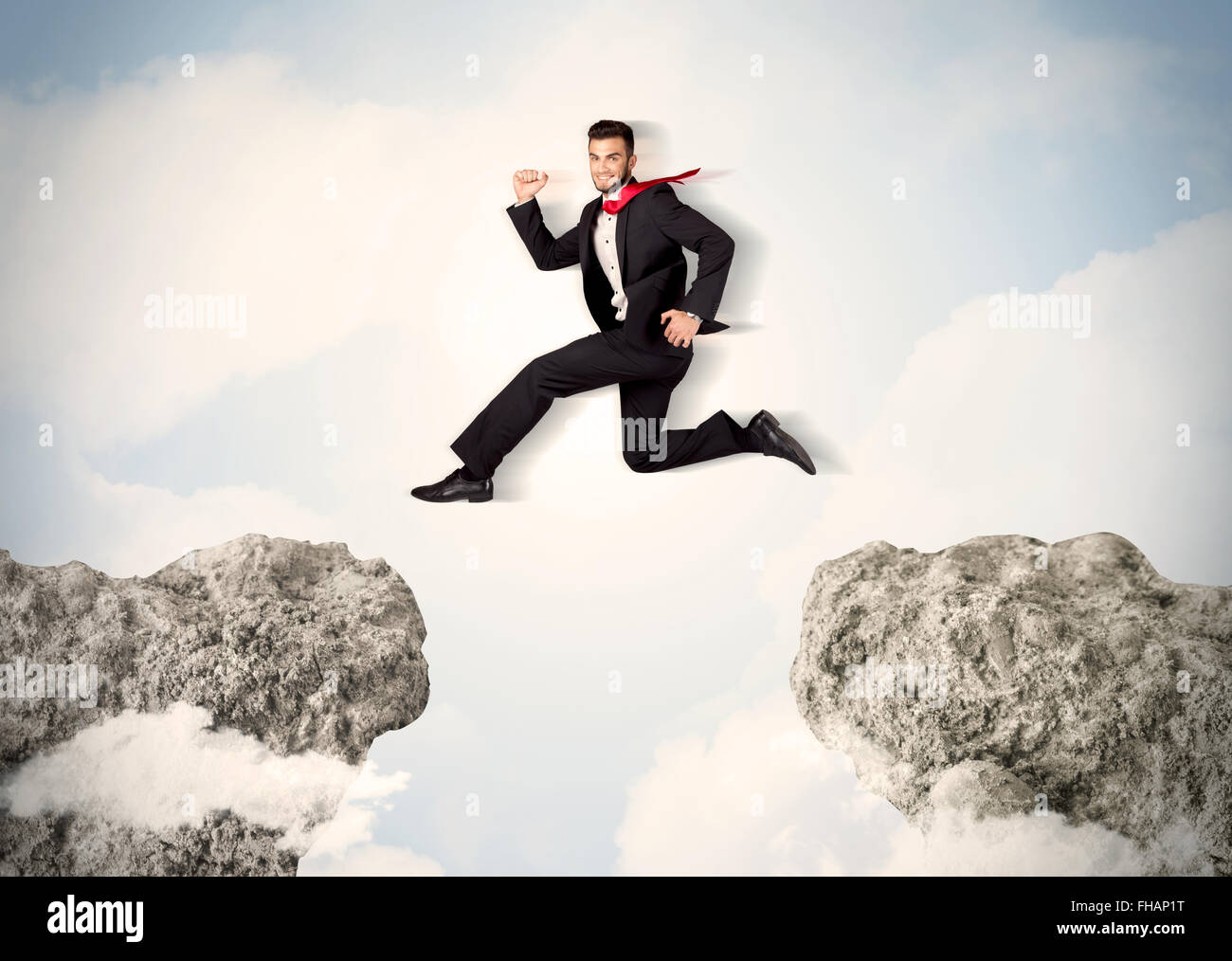 Happy business man jumping over a cliff Stock Photo - Alamy