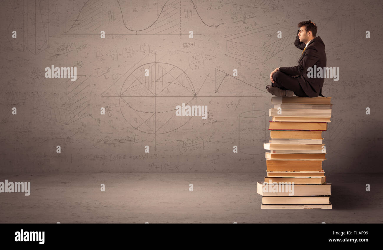 Businessman sitting on books Stock Photo - Alamy