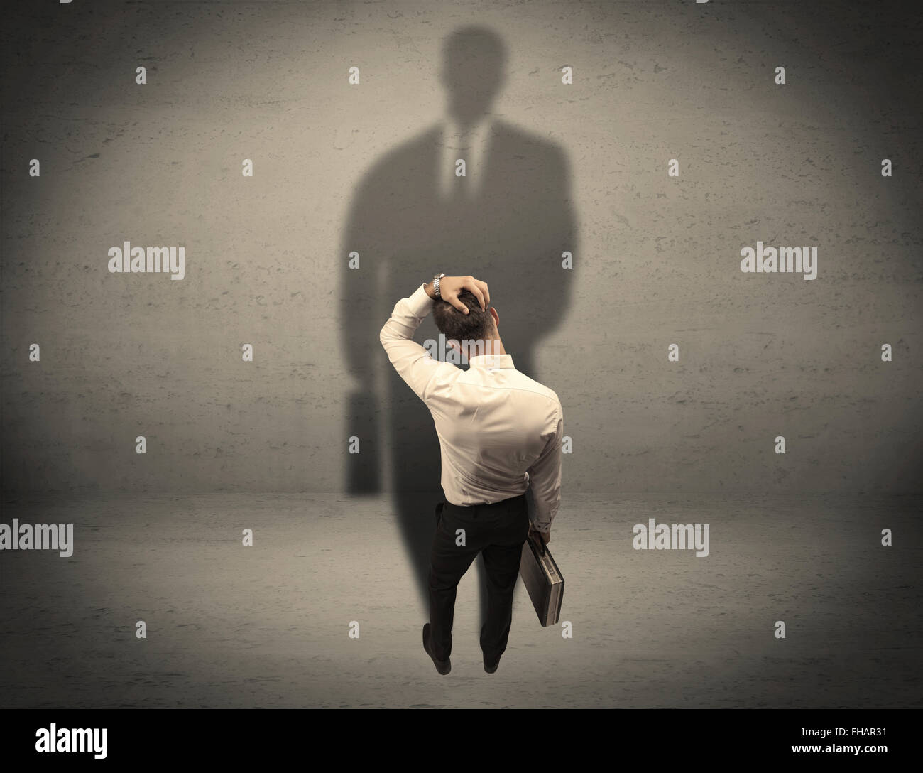 Businessman looking at big shadow concept Stock Photo - Alamy