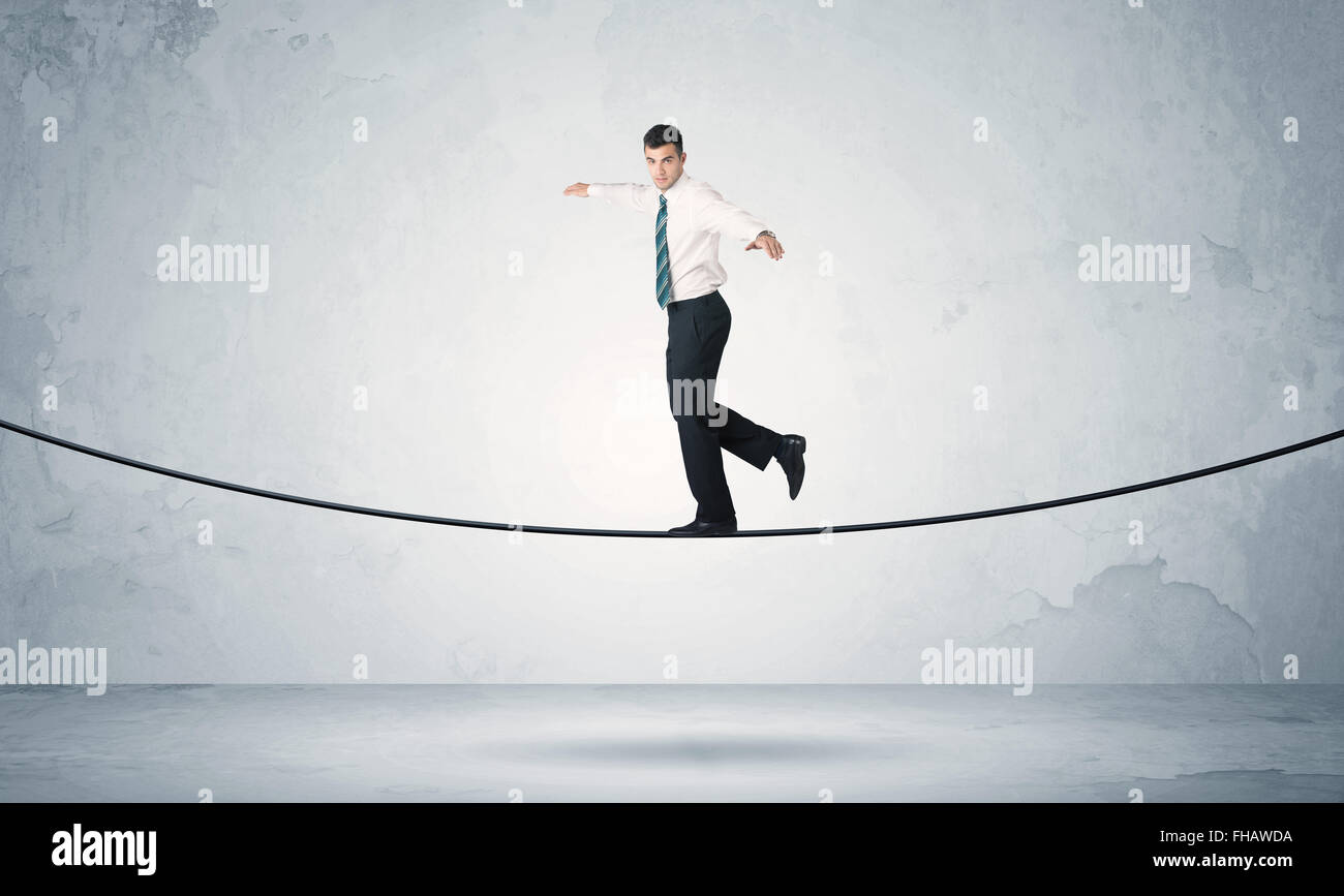 Sales guy balancing on tight rope Stock Photo - Alamy