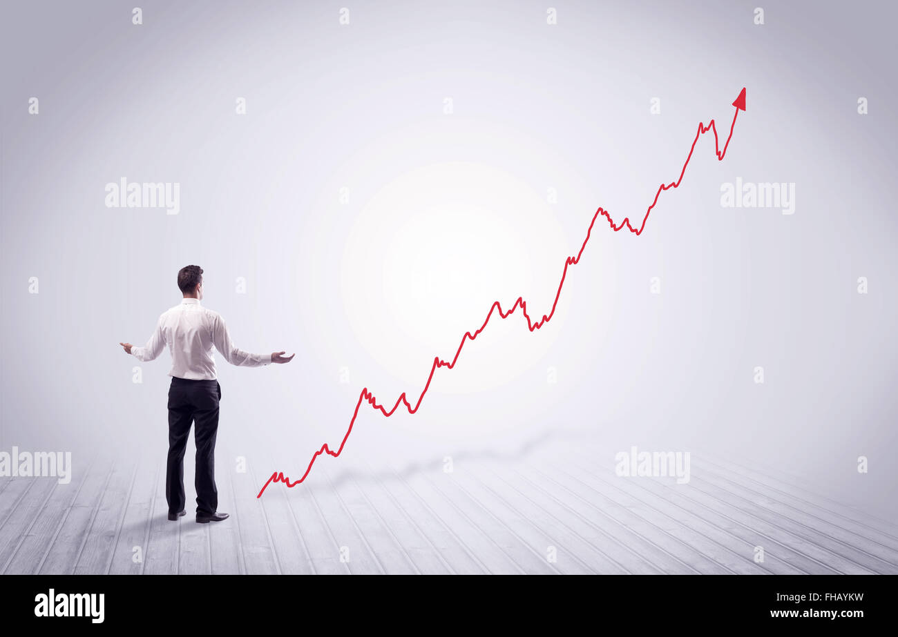 Standing businessman with red graph arrow Stock Photo - Alamy