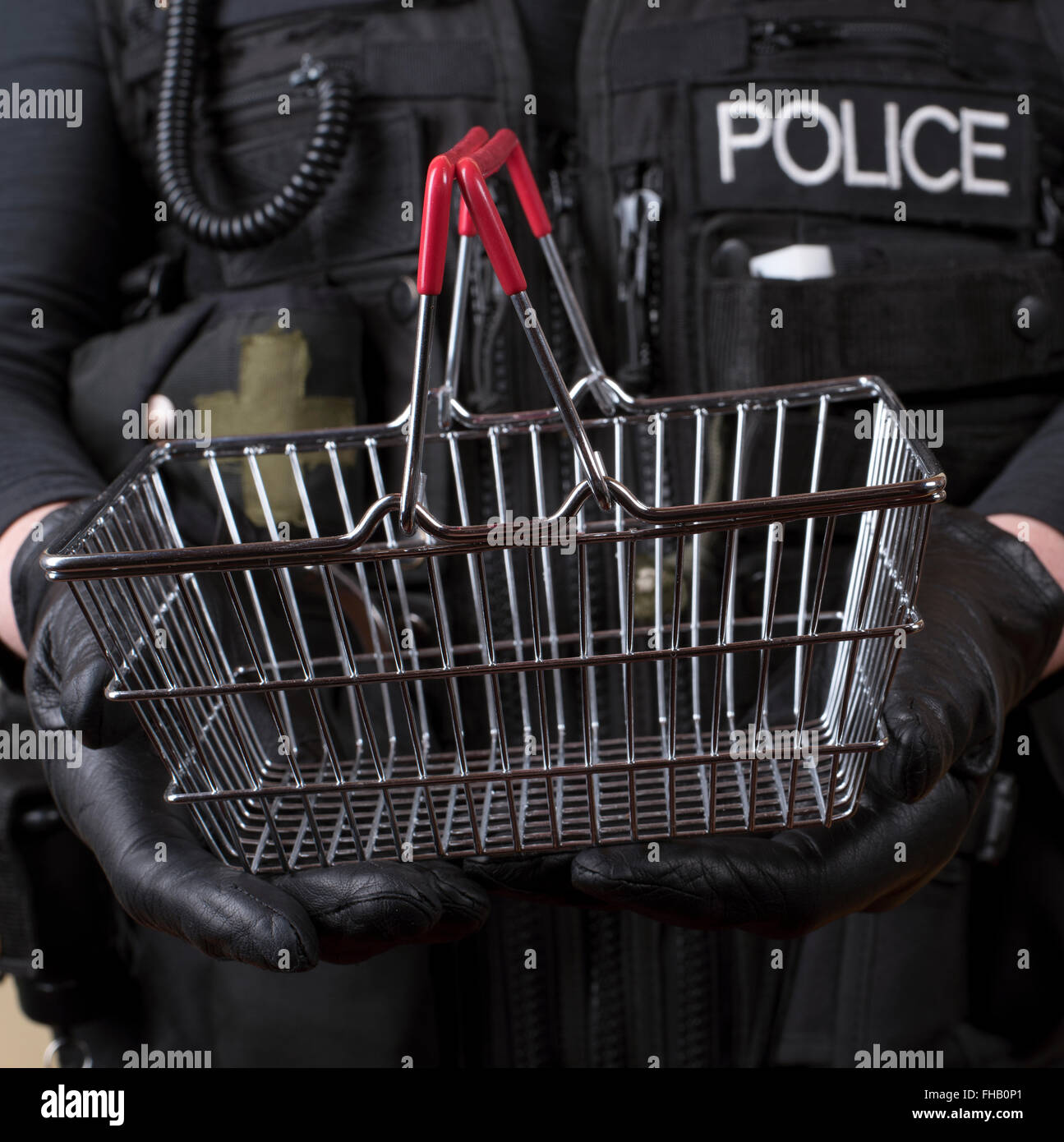 Police officer holding small wire shopping basket in shoplifting ...