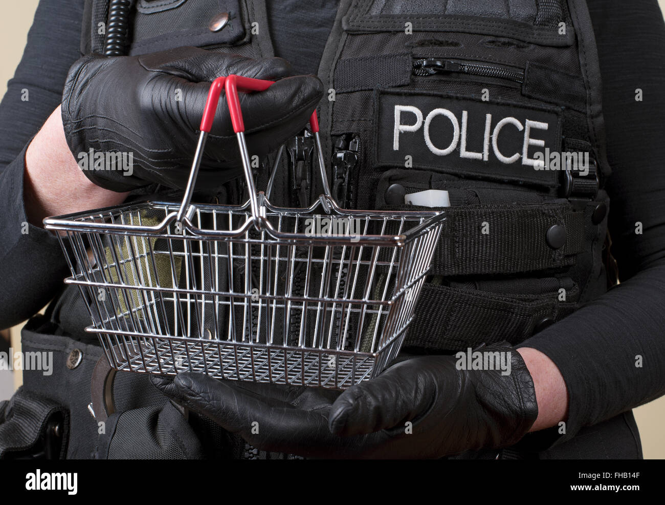 Police officer holding small wire shopping basket in shoplifting ...