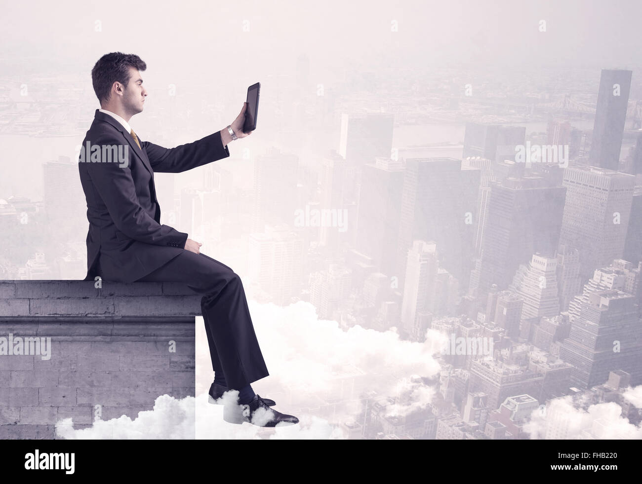 Sales person sitting on building edge in city Stock Photo - Alamy