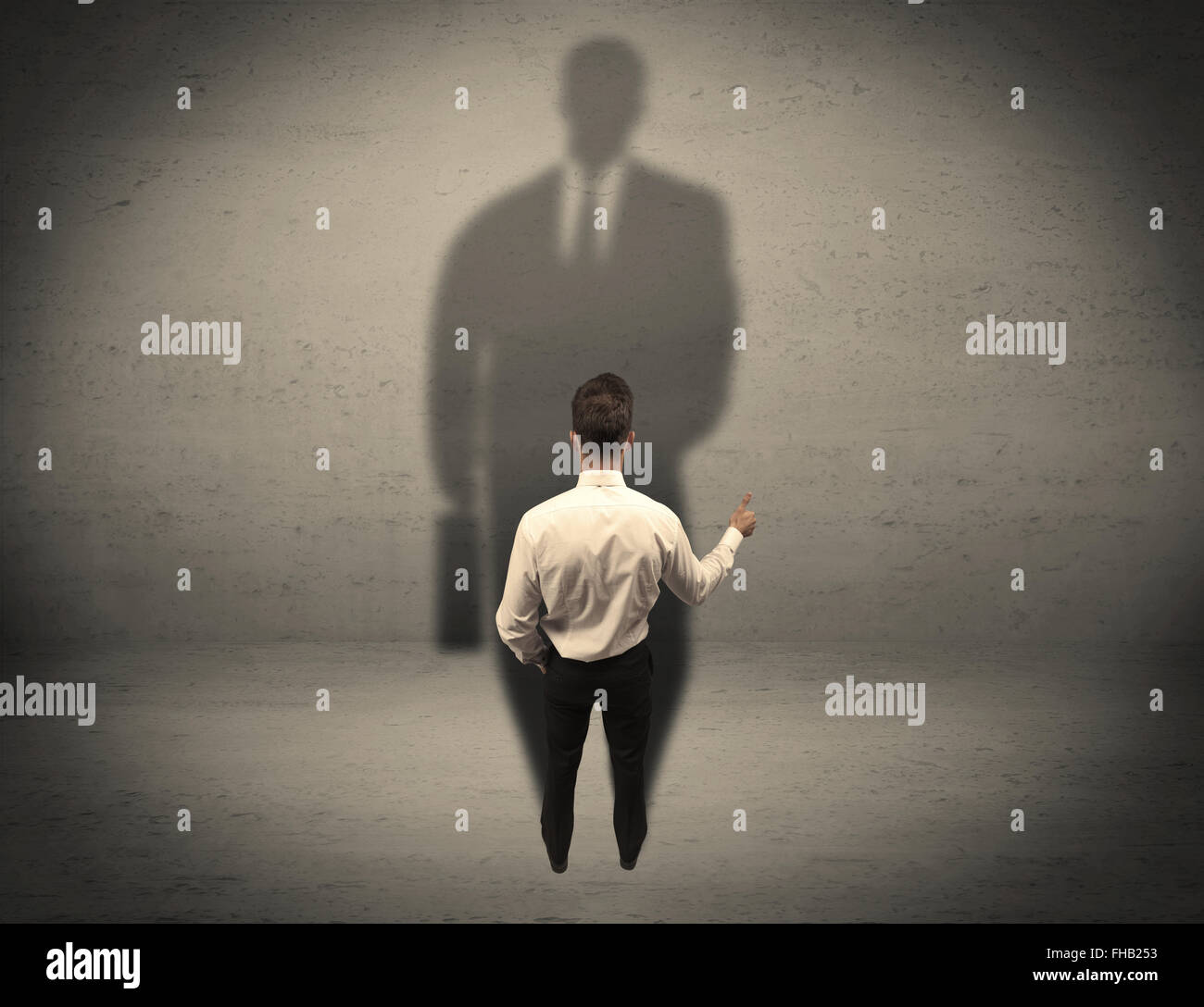 Businessman looking at big shadow concept Stock Photo - Alamy