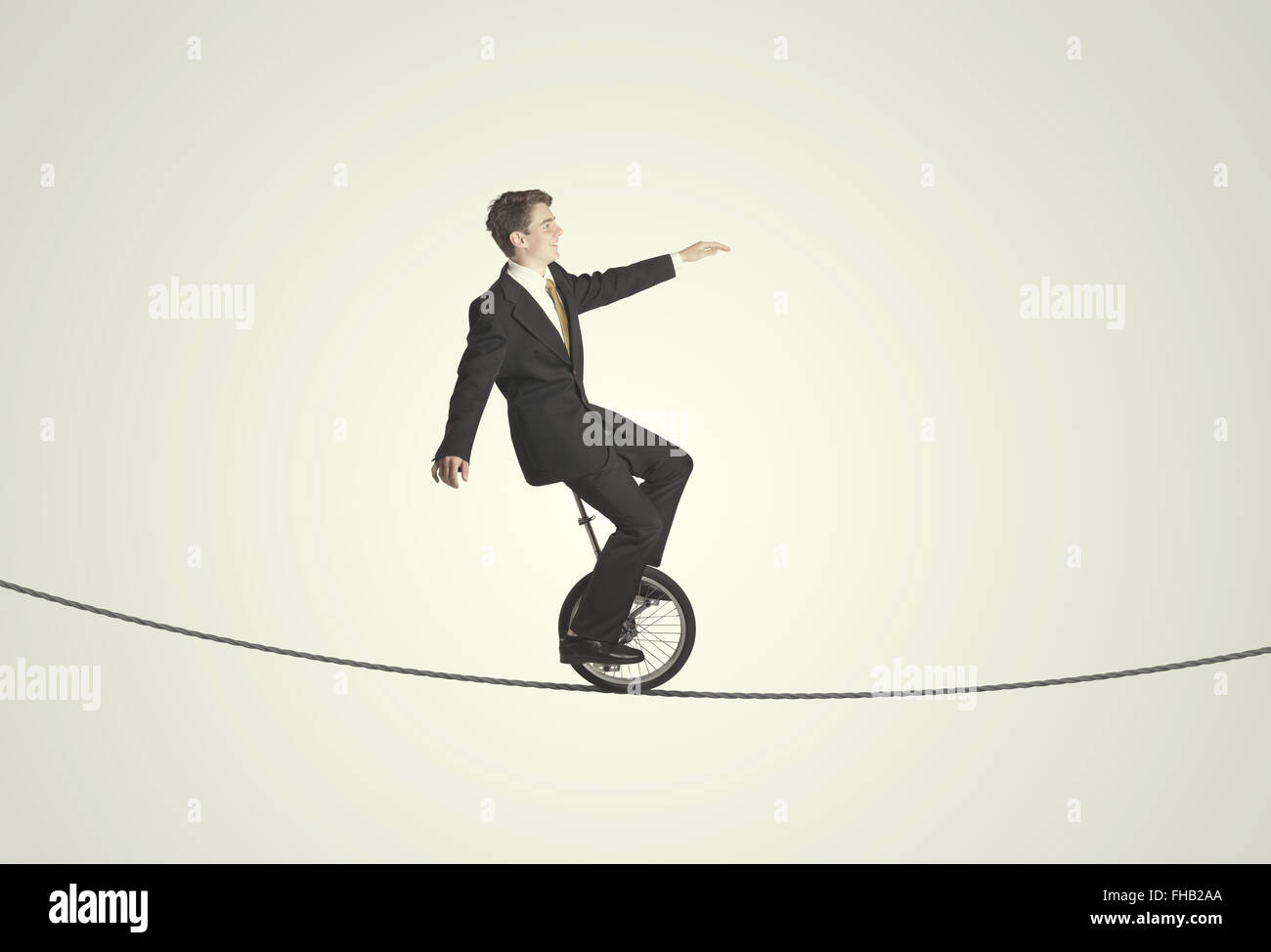 Brave business man riding an mono cycle between cliffs Stock Photo - Alamy