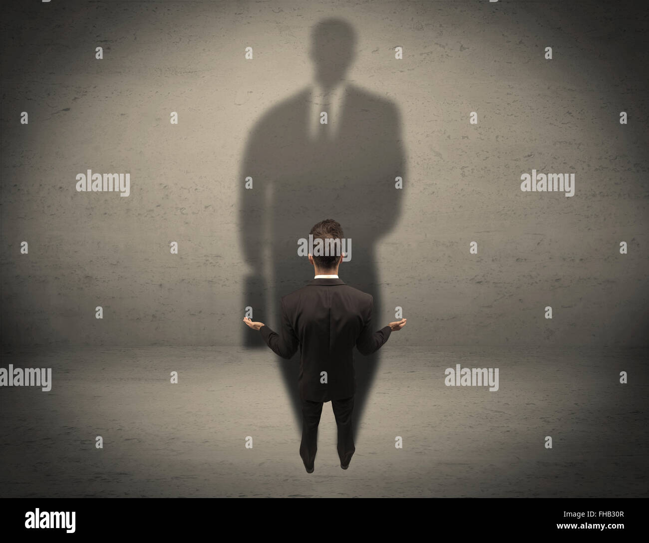 Businessman looking at big shadow concept Stock Photo - Alamy