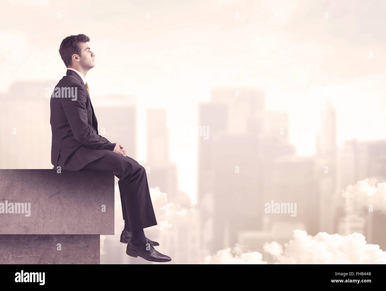 Peaceful sales guy sitting on roof top Stock Photo - Alamy