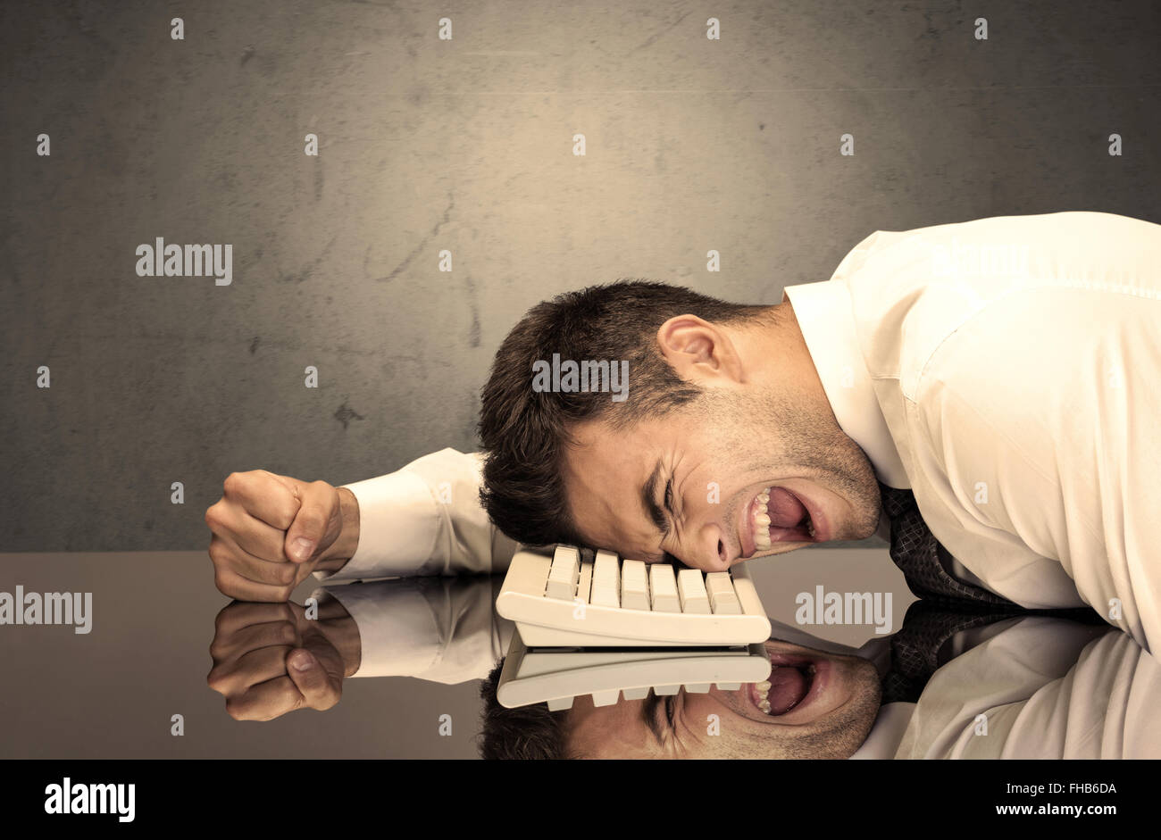 Frustrated businessman's head on keyboard Stock Photo - Alamy