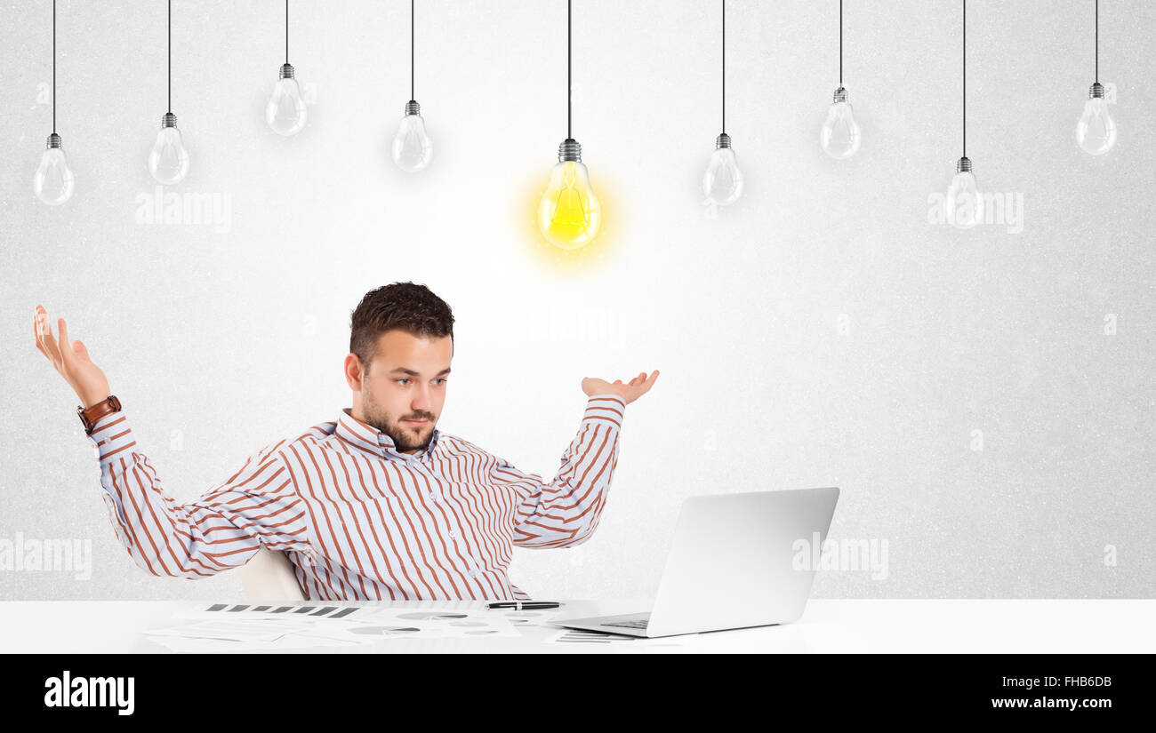 Business man sitting at table with idea light bulbs Stock Photo - Alamy