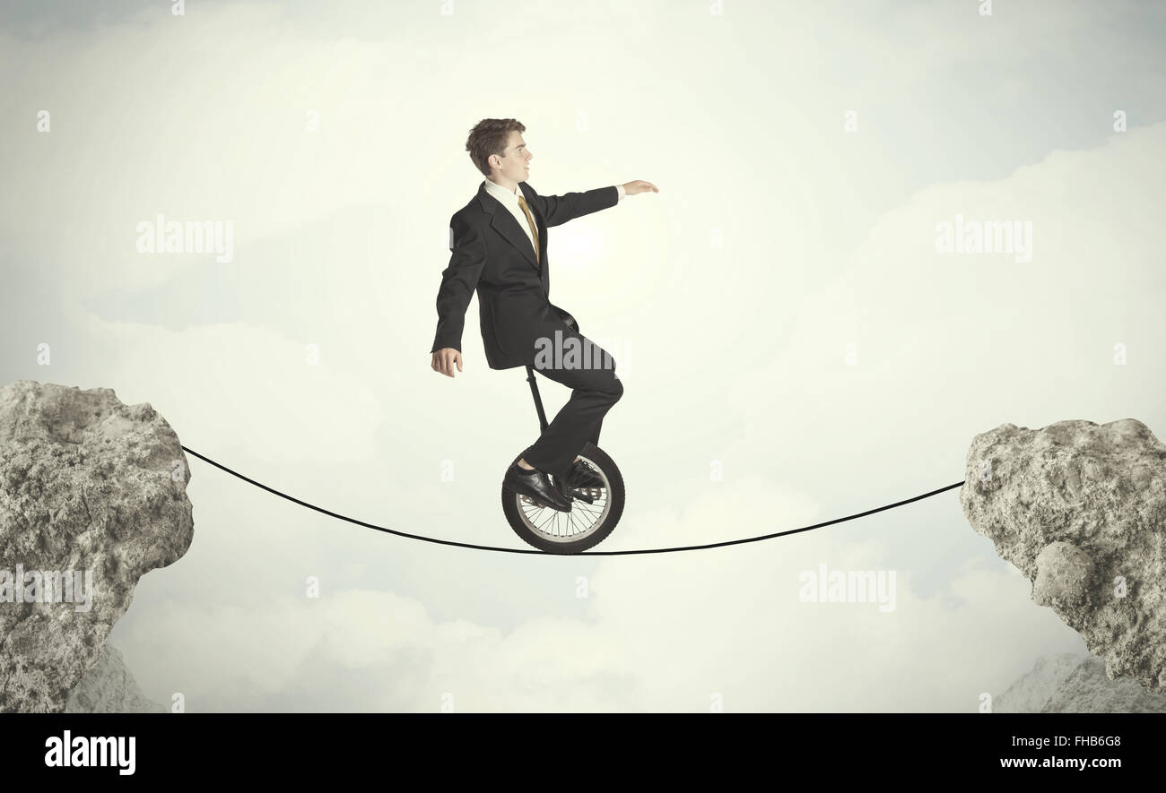 Brave business man riding an mono cycle between cliffs Stock Photo - Alamy