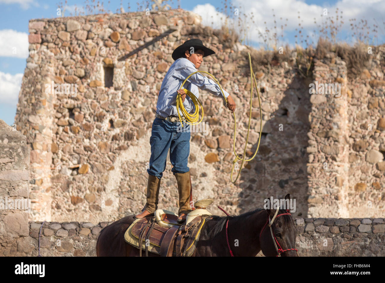 A Mexican charro or cowboy practices roping skills on his horse before ...