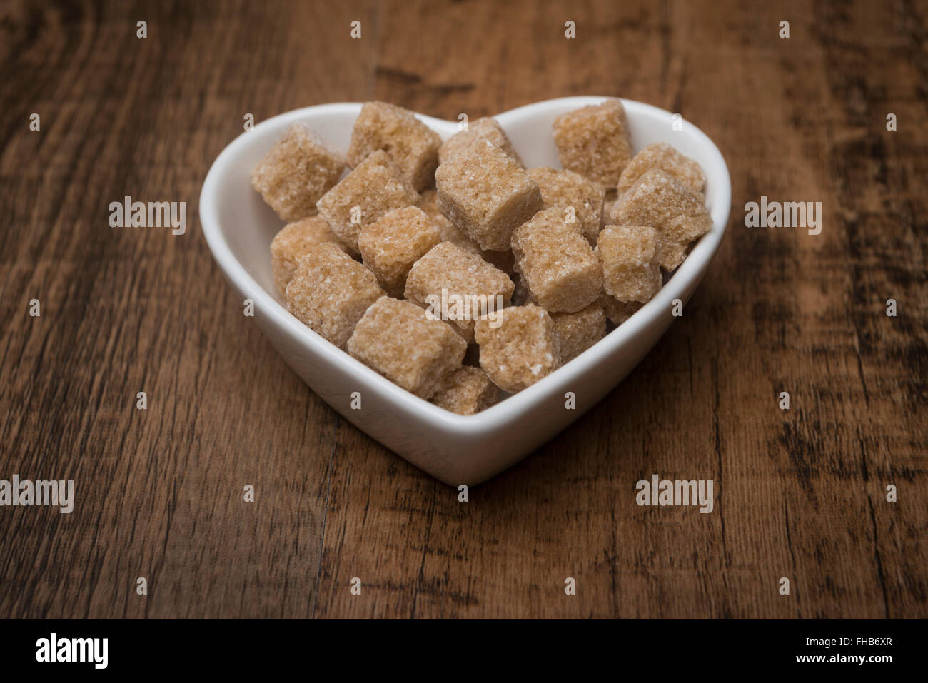 Brown sugar cubes in a heart shaped bowl Stock Photo - Alamy