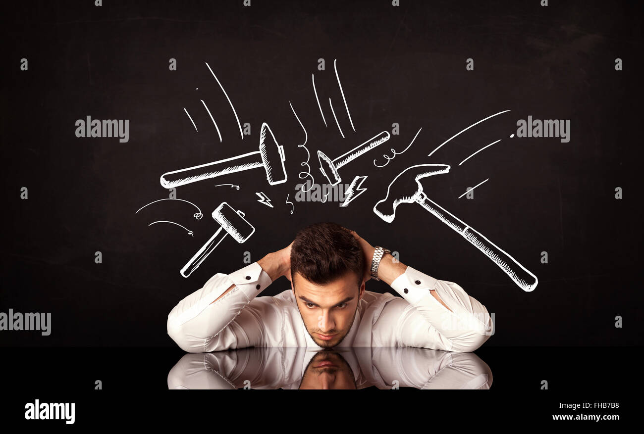 Depressed businessman sitting under hammer marks Stock Photo - Alamy
