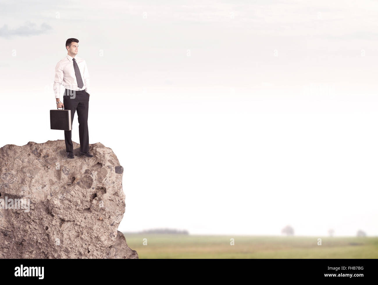 Happy salesman on cliff in the country Stock Photo - Alamy