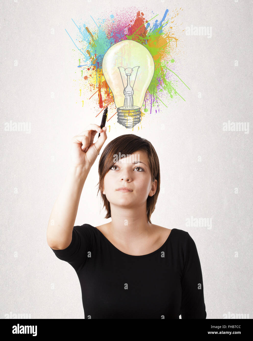 Young lady drawing a colorful light bulb with colorful splashes Stock ...