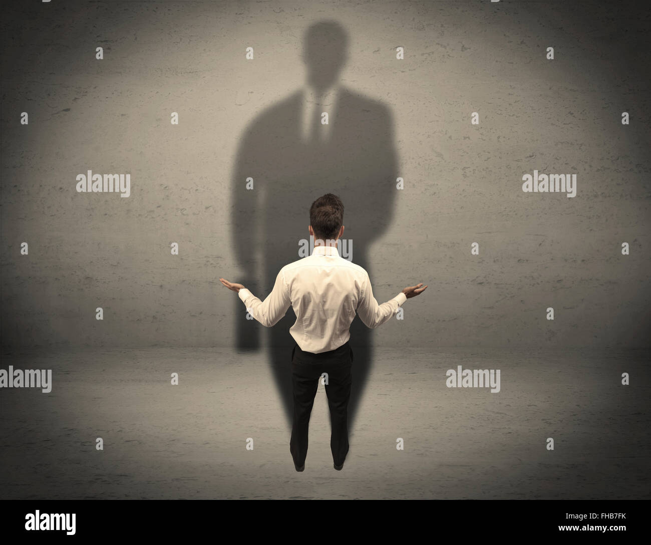 Businessman looking at big shadow concept Stock Photo - Alamy
