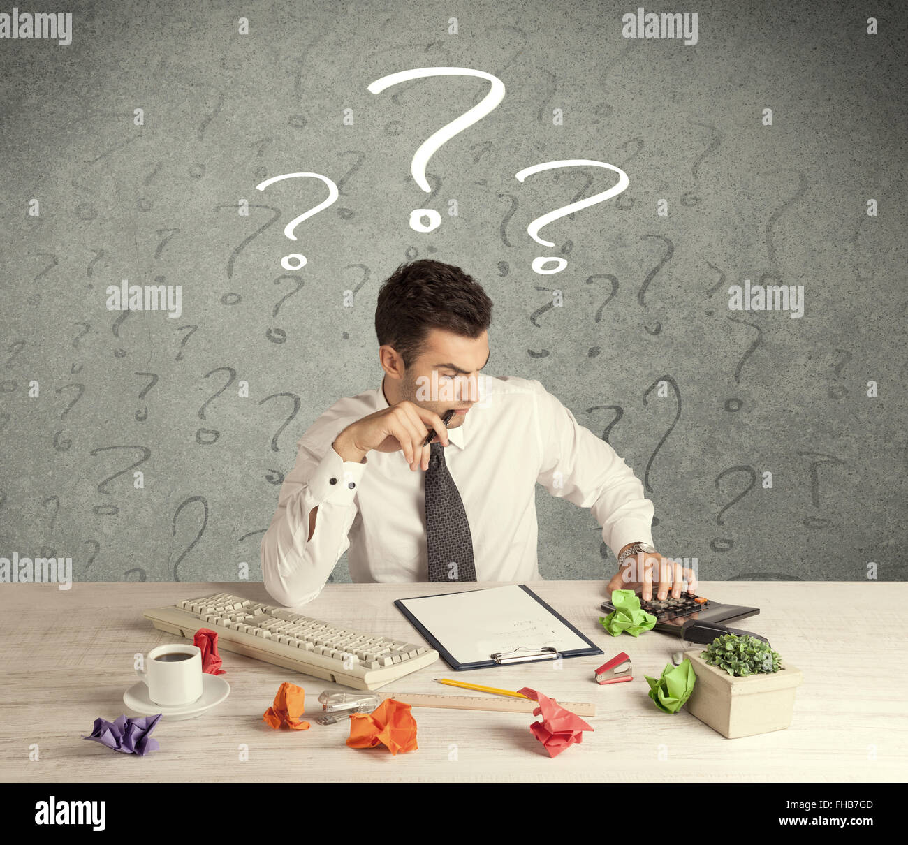 Businessman at desk with question mark Stock Photo - Alamy