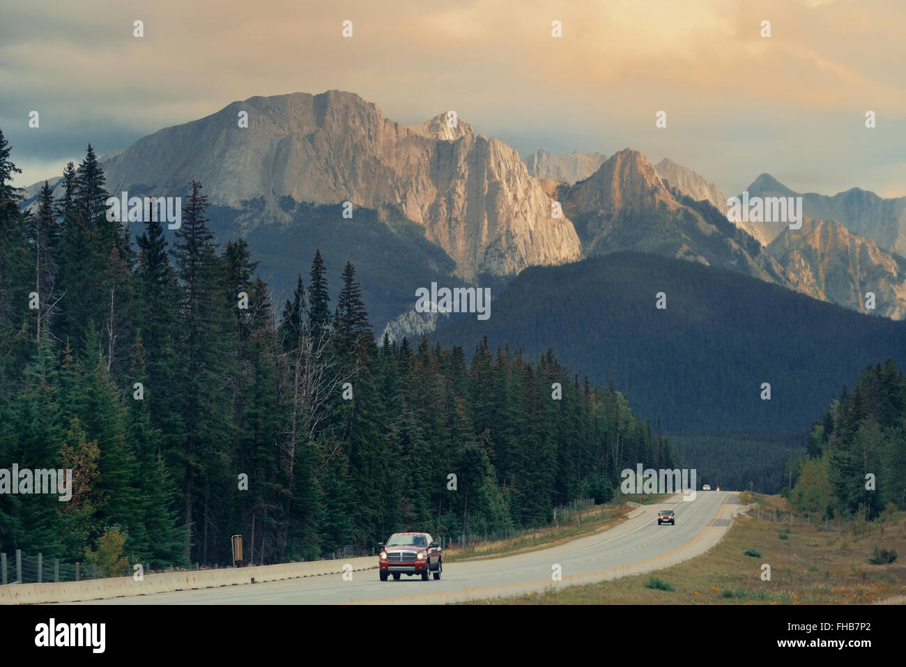 Highway in Banff national park at sunset with mountains and forest in ...