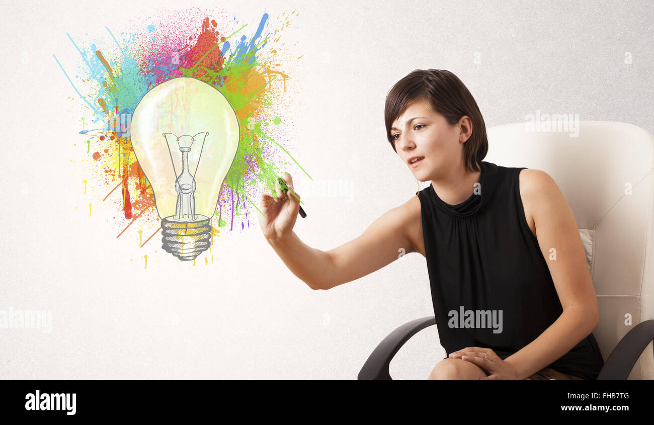 Young lady drawing a colorful light bulb with colorful splashes Stock ...