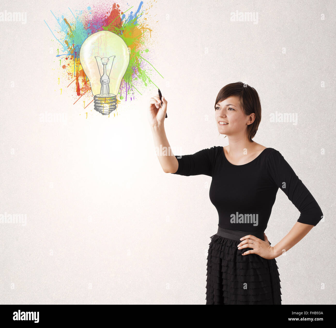 Young lady drawing a colorful light bulb with colorful splashes Stock ...