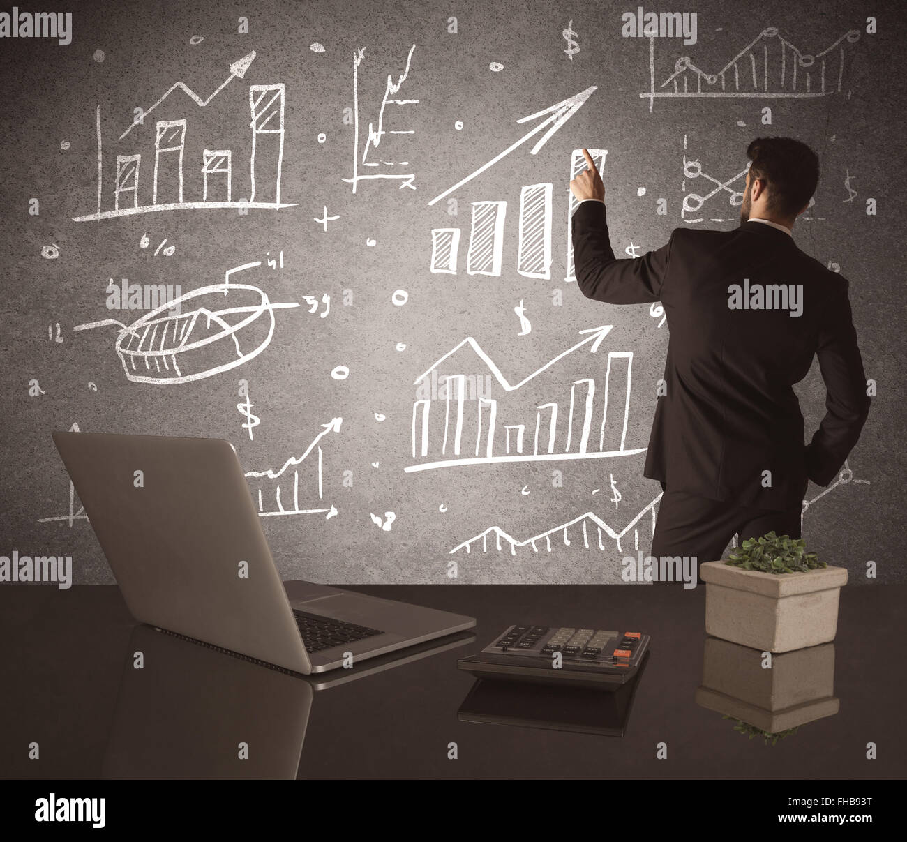 Businessman drawing sales charts on wall Stock Photo - Alamy