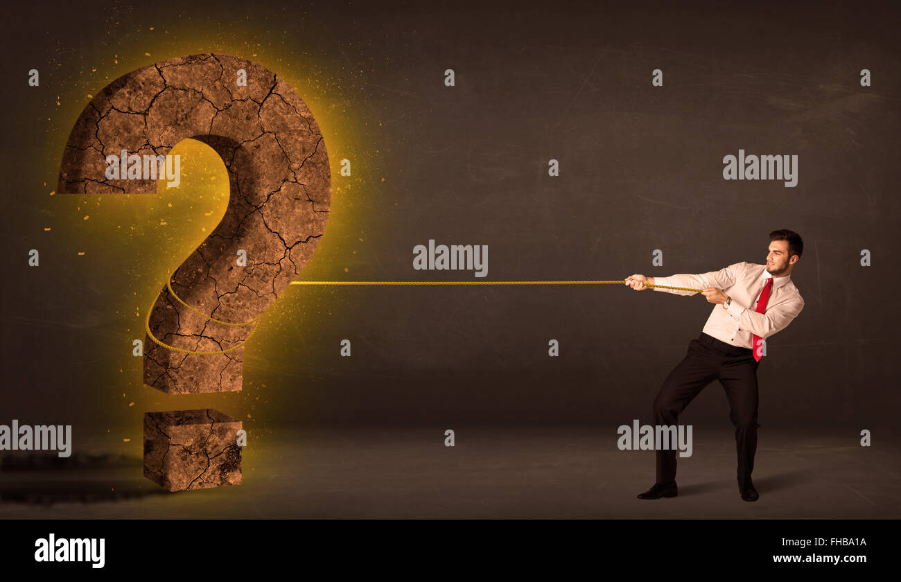 Business man pulling a big solid question mark stone Stock Photo - Alamy
