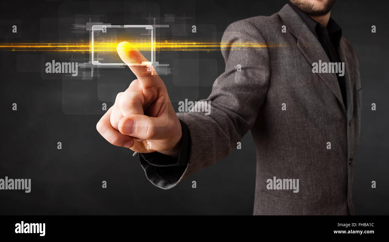 Tech business person touching button with orange light beams concept ...