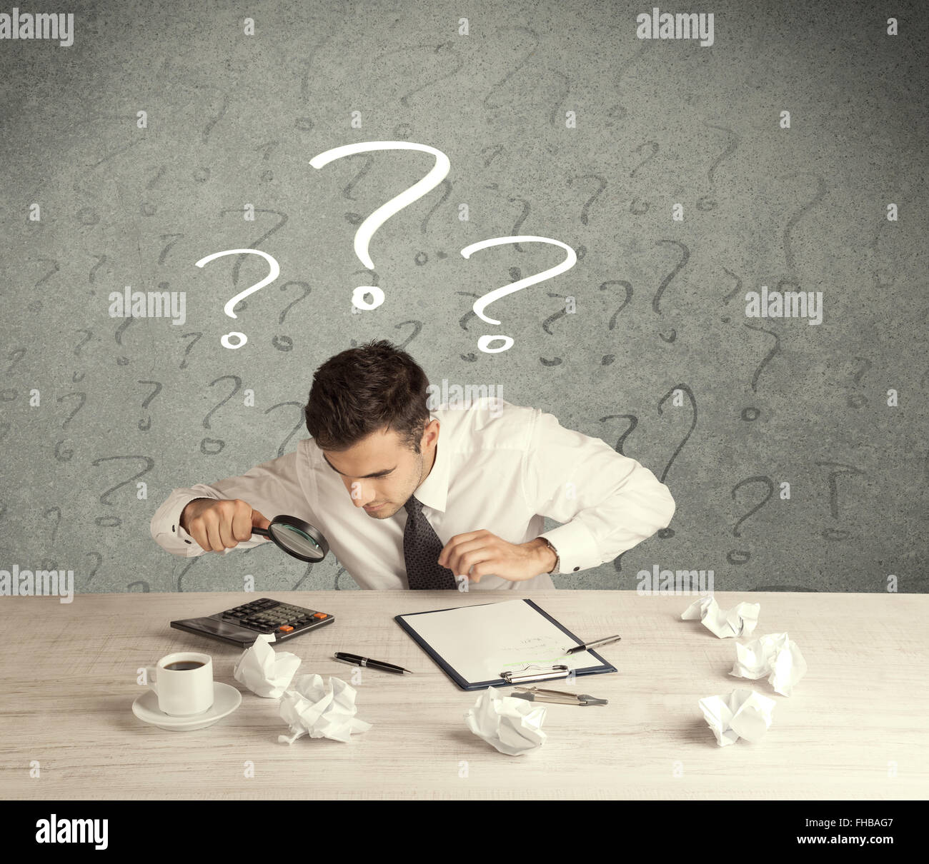 Businessman at desk with question mark Stock Photo - Alamy