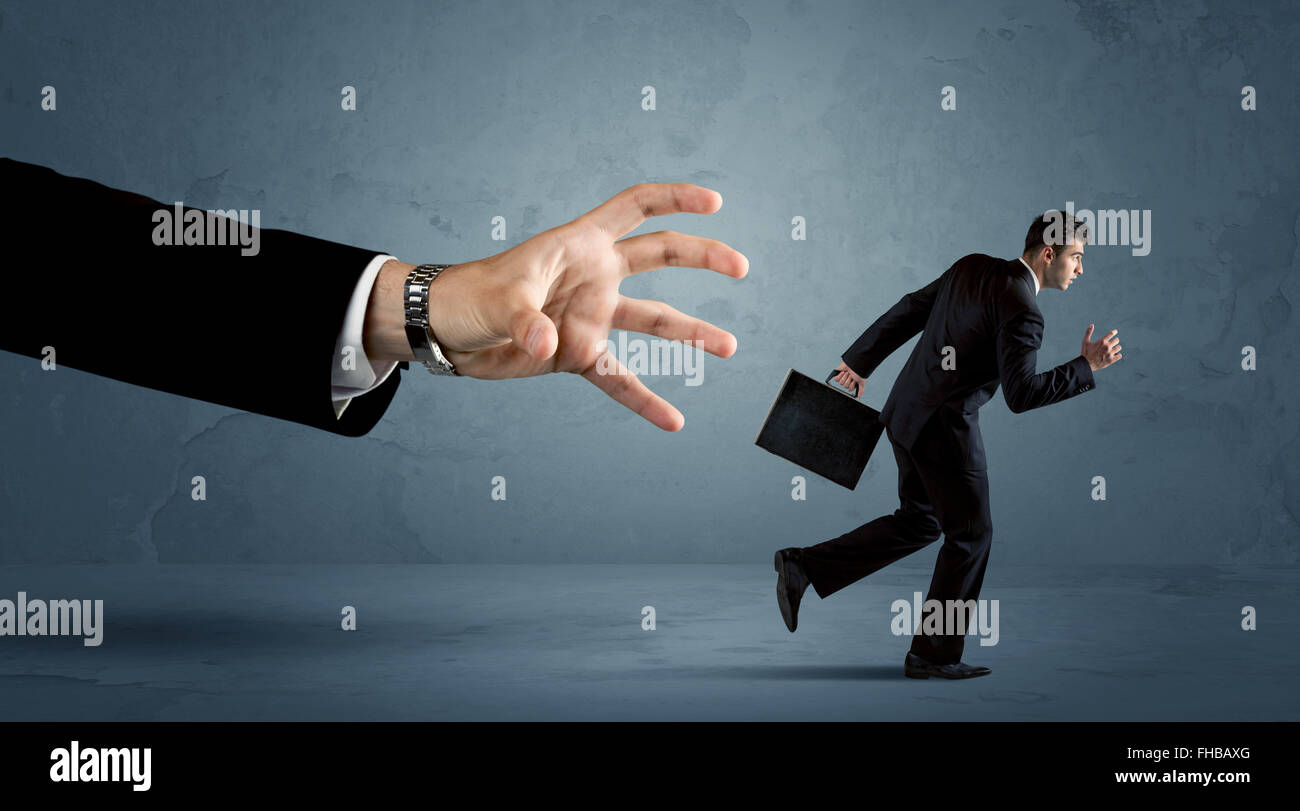 Business man running away from a huge hand concept Stock Photo - Alamy