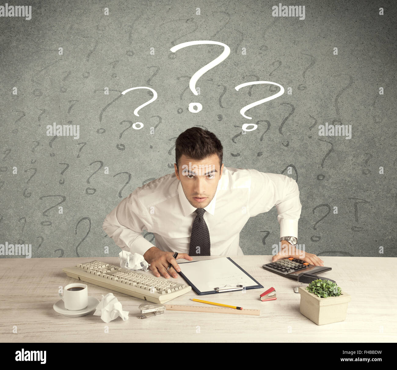 Businessman at desk with question mark Stock Photo - Alamy