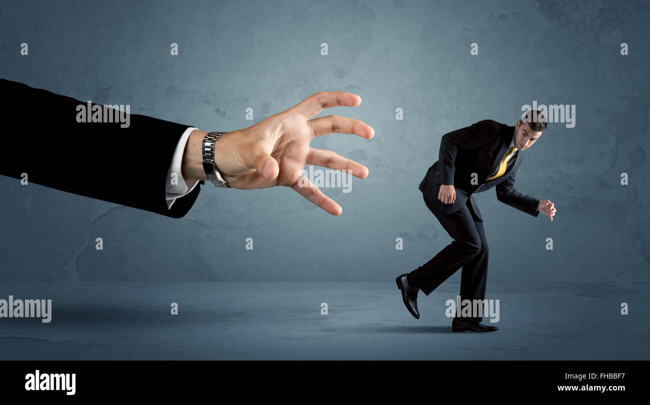 Business man running away from a huge hand concept Stock Photo - Alamy