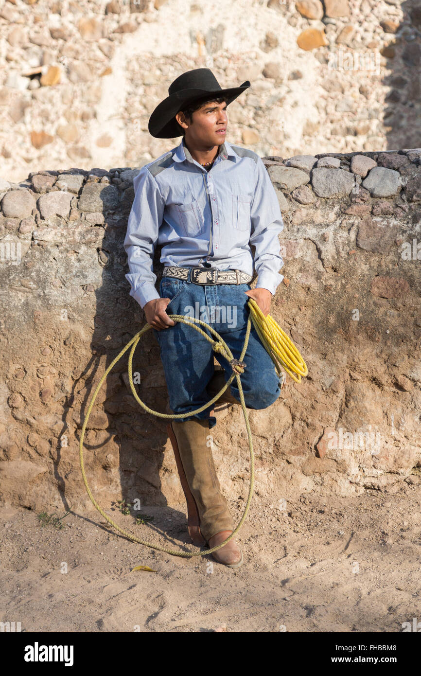 A Mexican charro or cowboy poses in cowboy hat and lasso at a hacienda ...