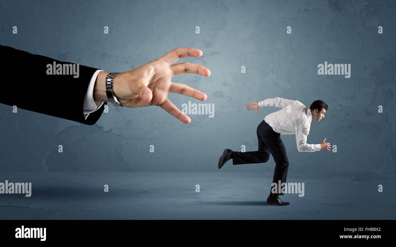 Business man running away from a huge hand concept Stock Photo - Alamy