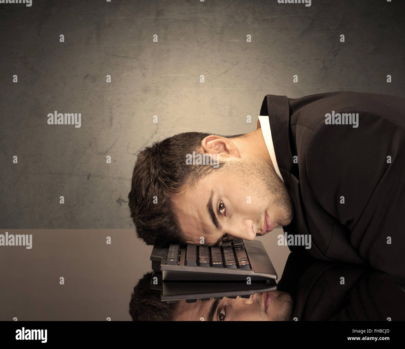 Frustrated businessman's head on keyboard Stock Photo - Alamy