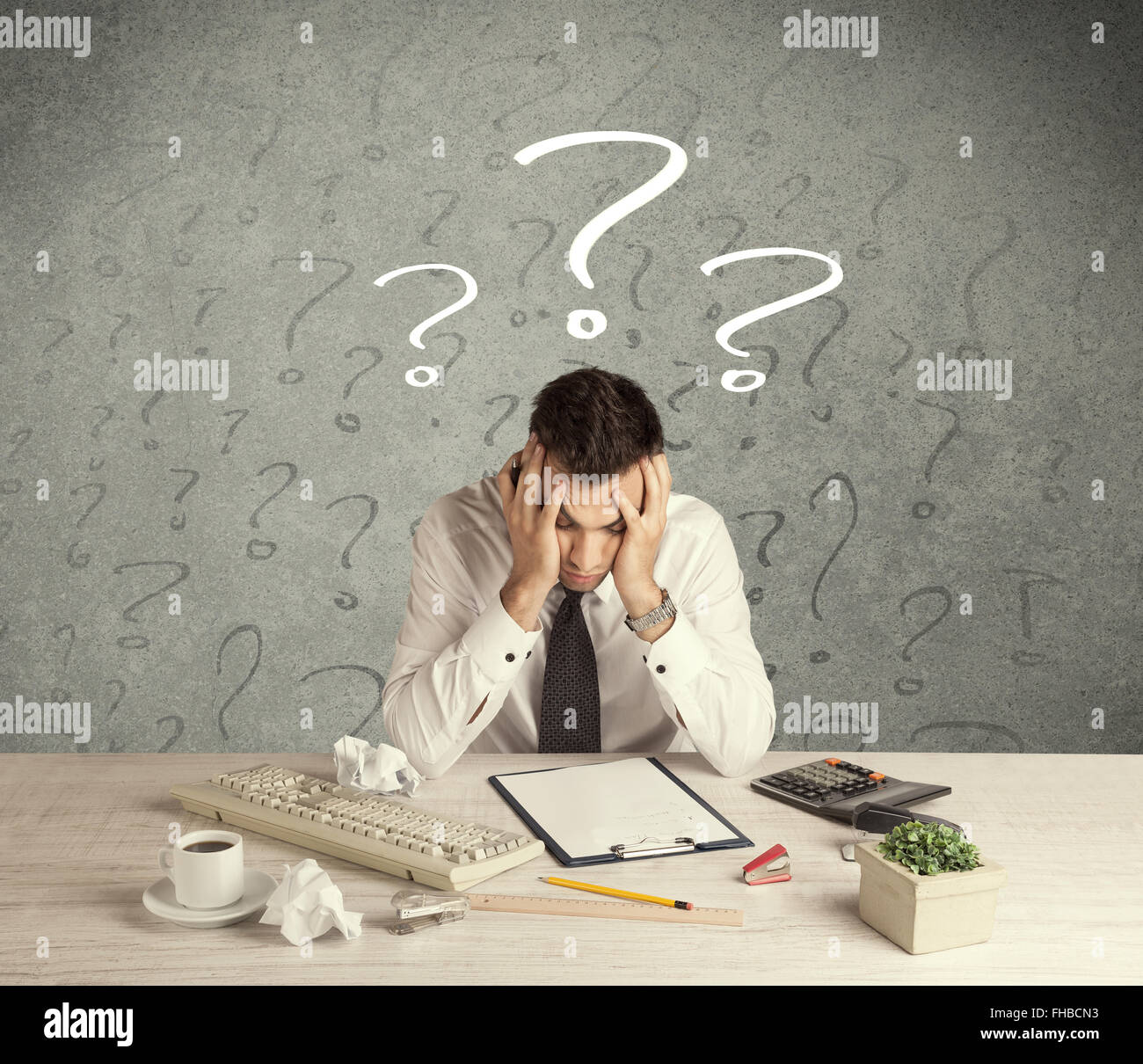 Businessman at desk with question mark Stock Photo - Alamy