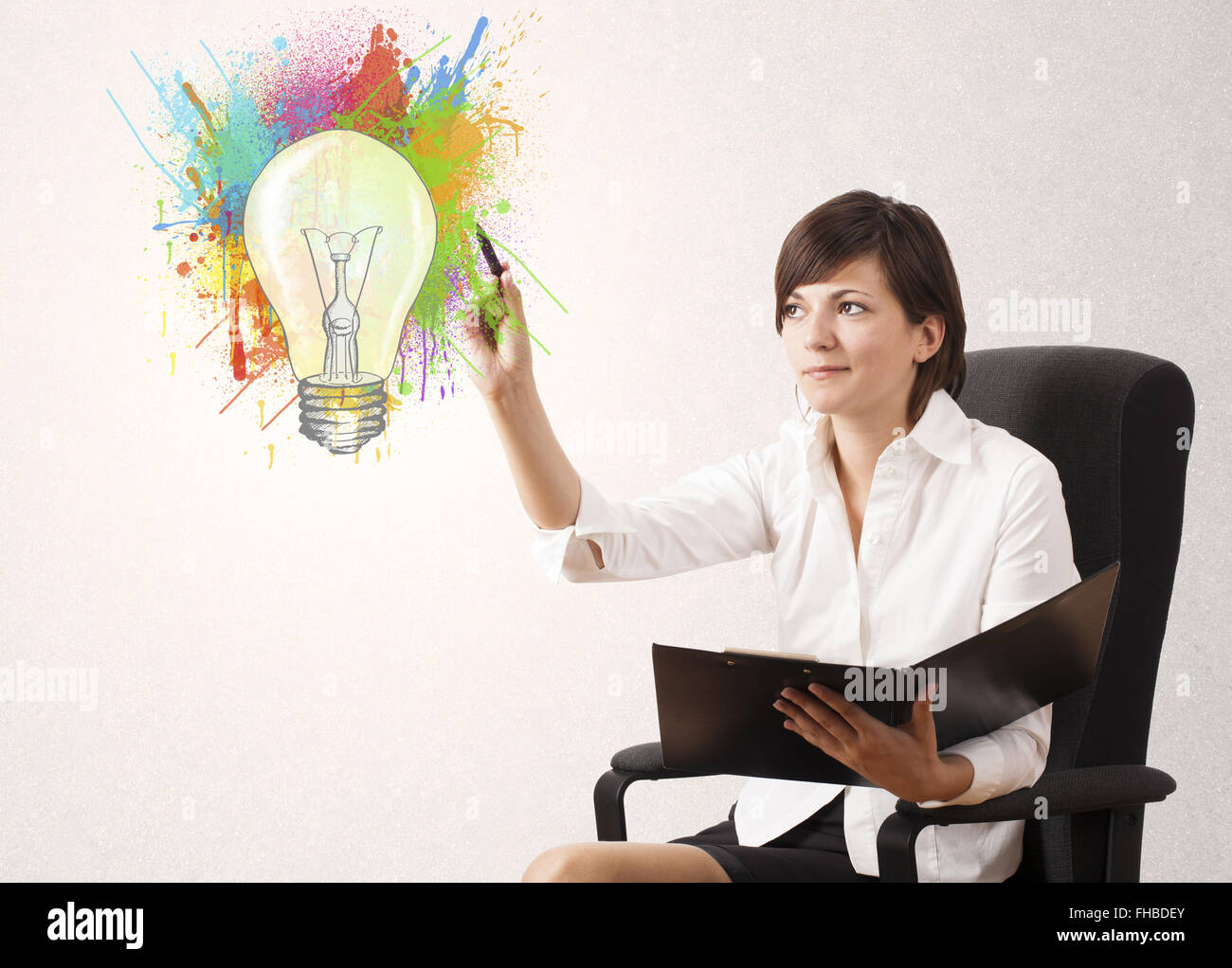 Young lady drawing a colorful light bulb with colorful splashes Stock ...