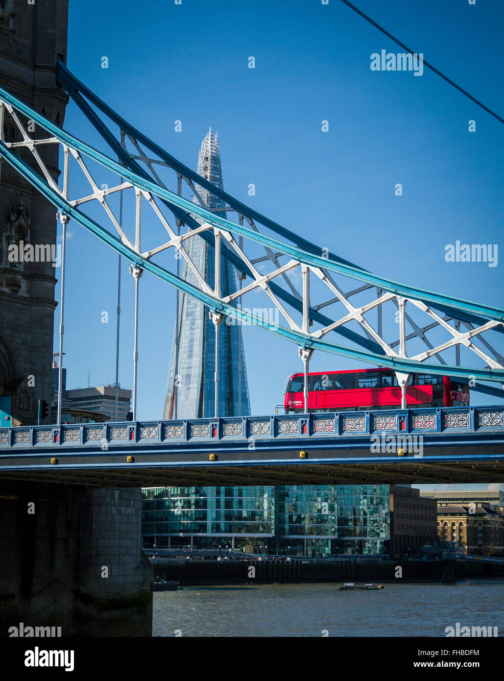 Red London double decker bus crosses Tower Bridge with The Shard in the ...