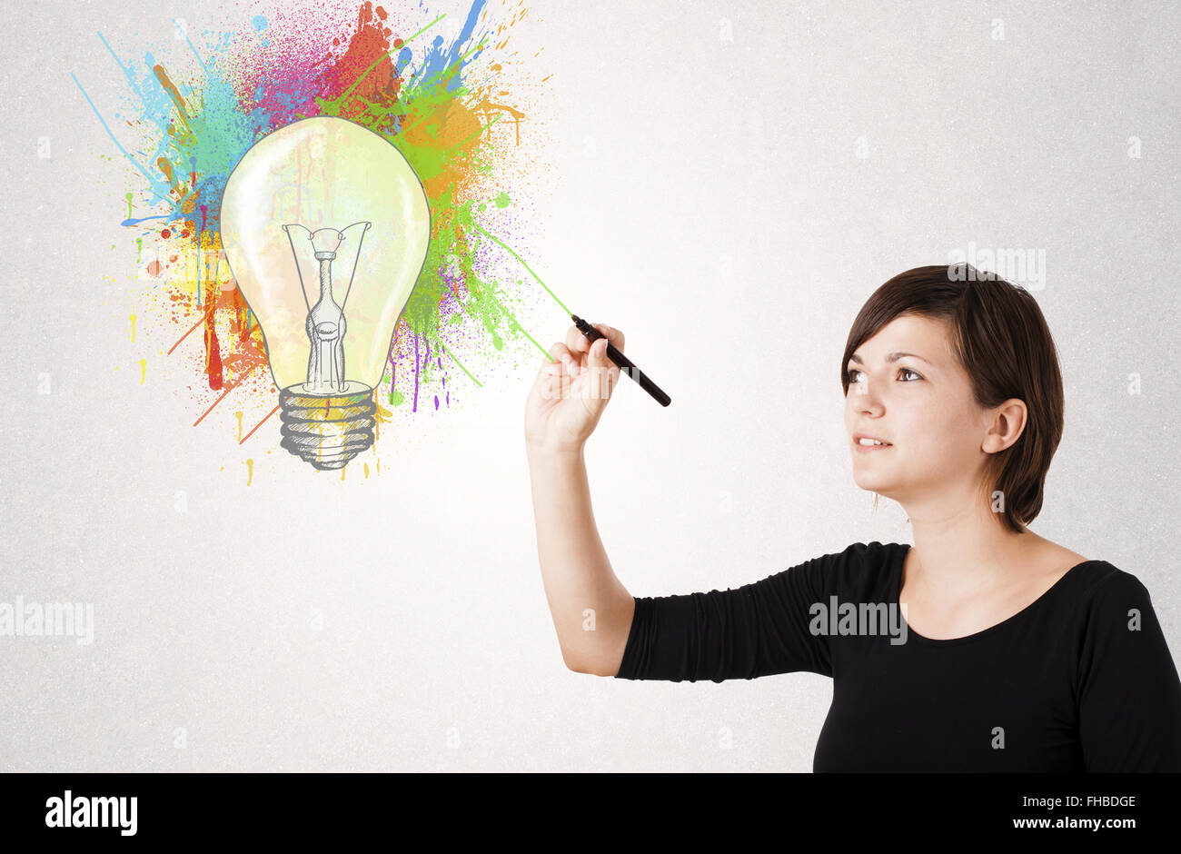 Young lady drawing a colorful light bulb with colorful splashes Stock ...