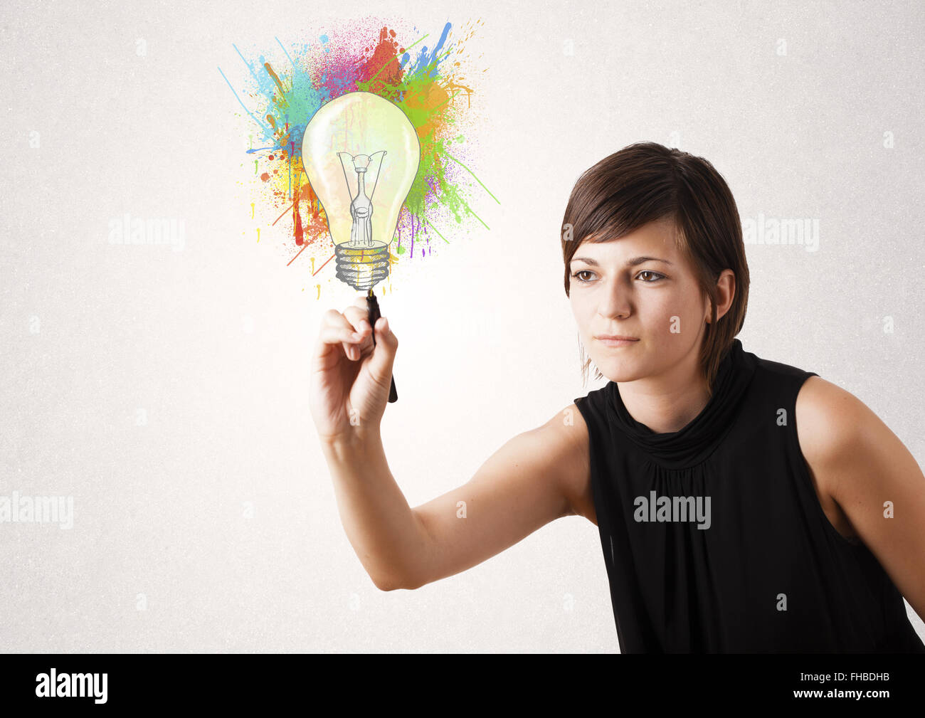 Young lady drawing a colorful light bulb with colorful splashes Stock ...