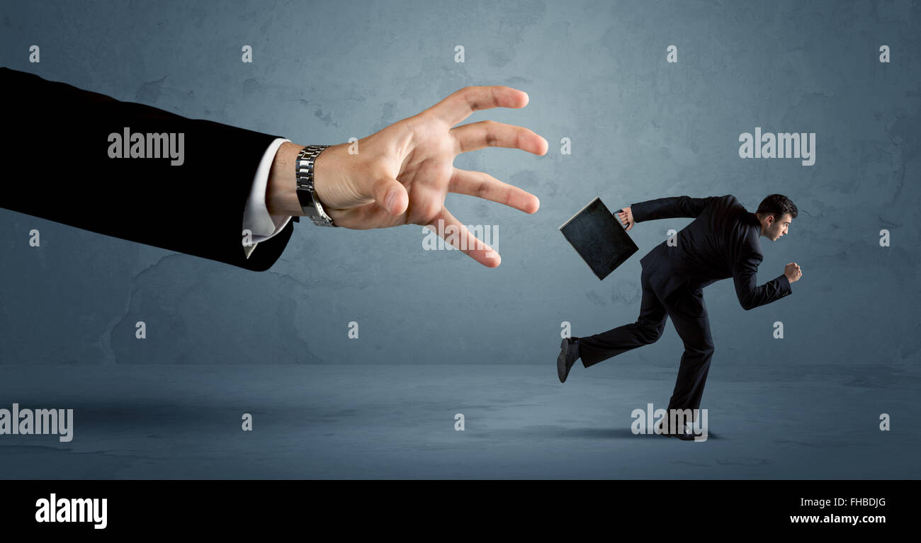 Business man running away from a huge hand concept Stock Photo - Alamy