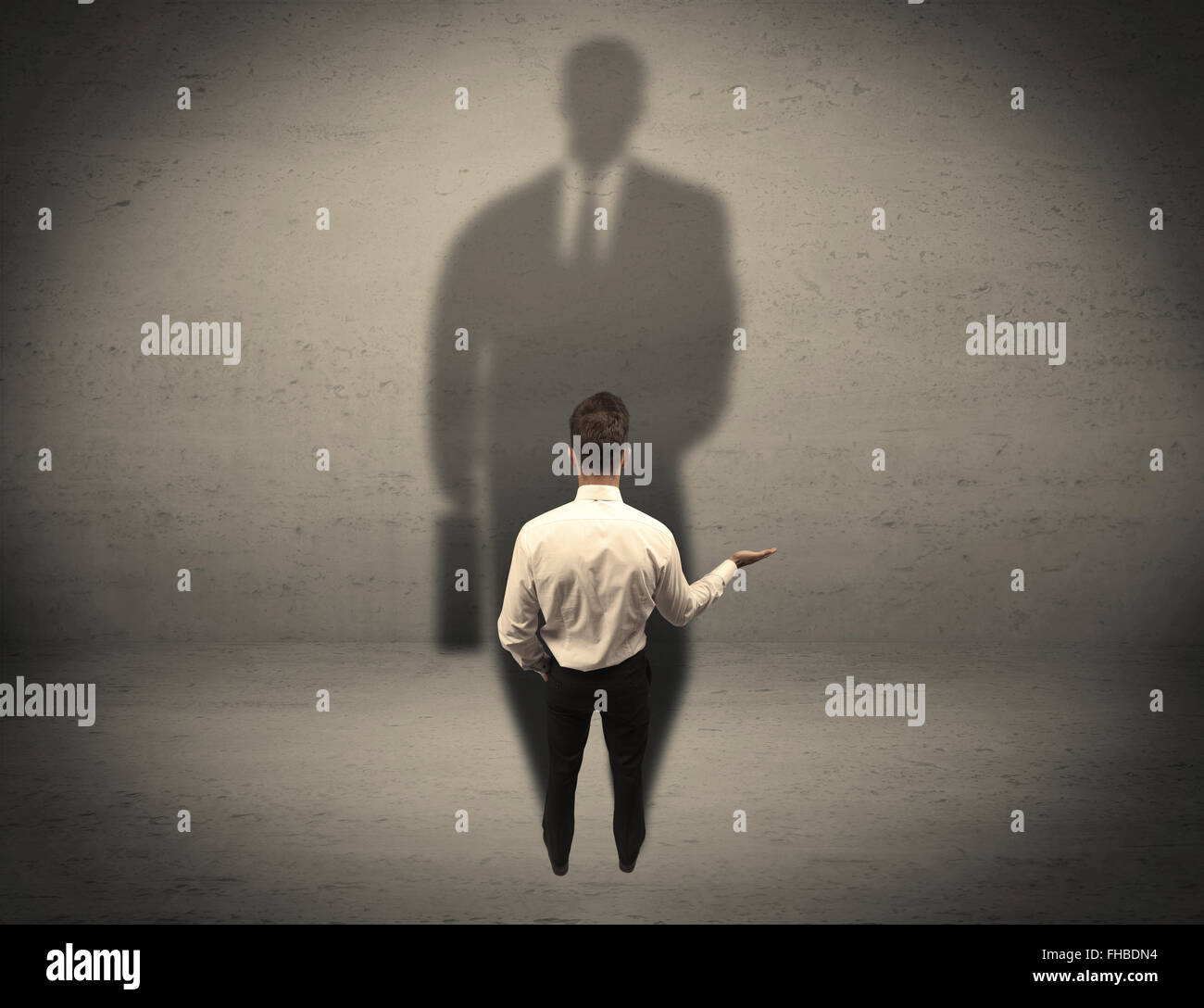 Businessman looking at big shadow concept Stock Photo - Alamy