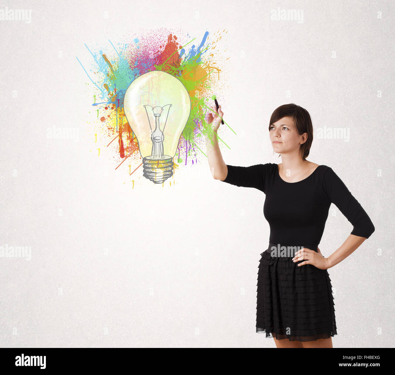 Young lady drawing a colorful light bulb with colorful splashes Stock ...