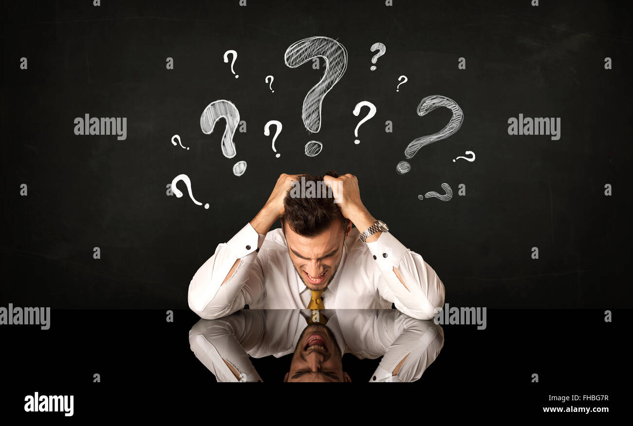 Sitting businessman under question marks Stock Photo - Alamy