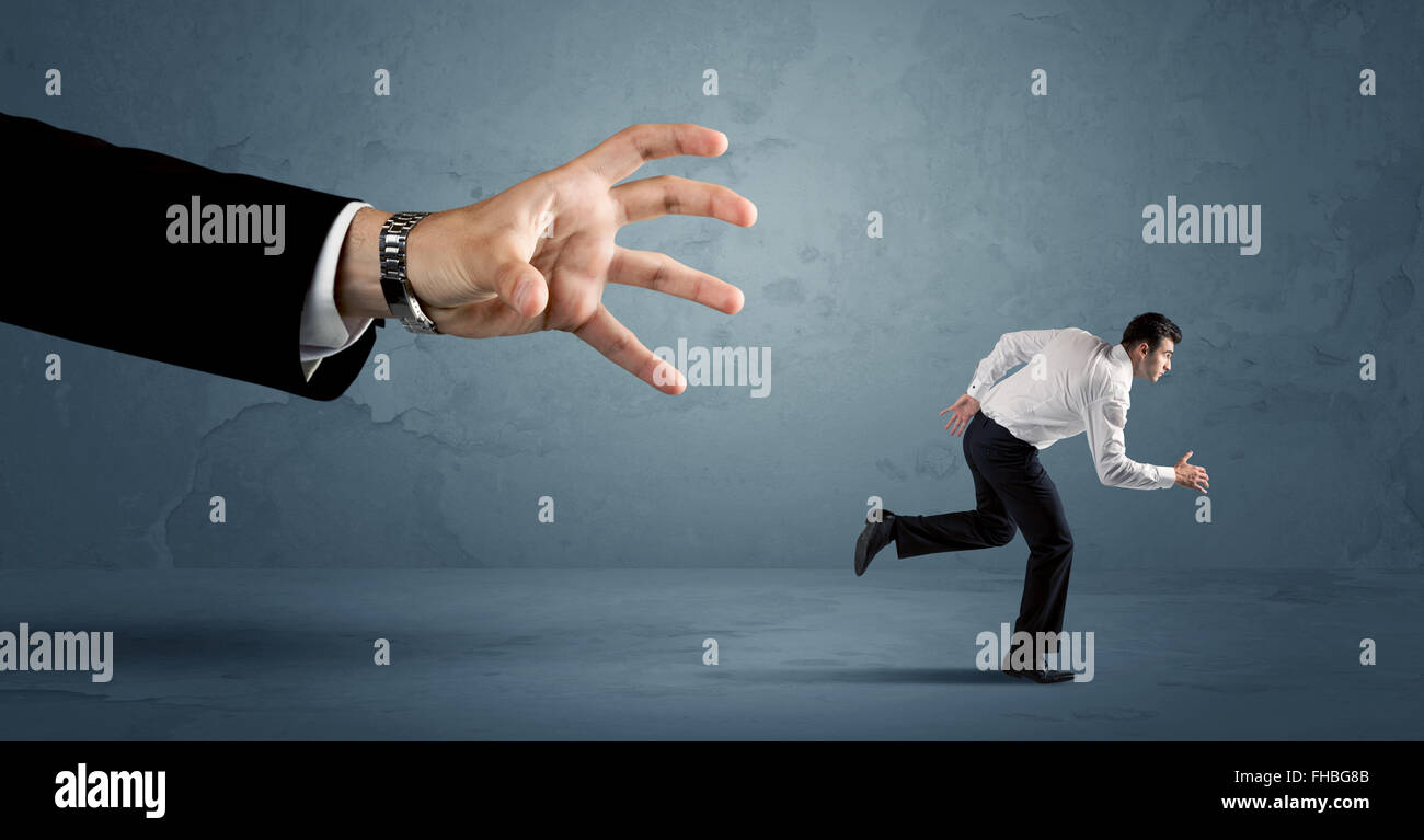 Business man running away from a huge hand concept Stock Photo - Alamy