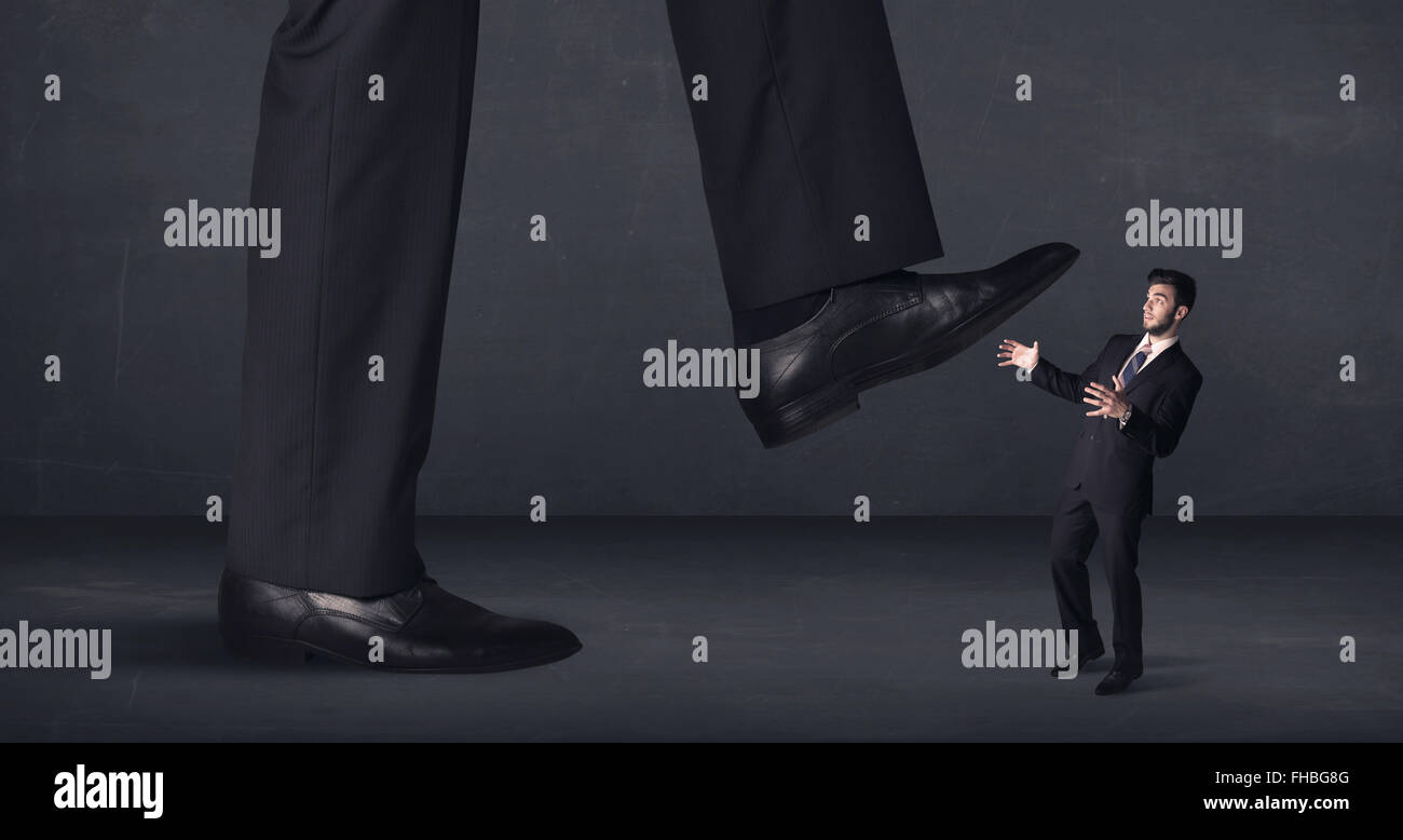 Giant person stepping on a little businessman concept Stock Photo - Alamy